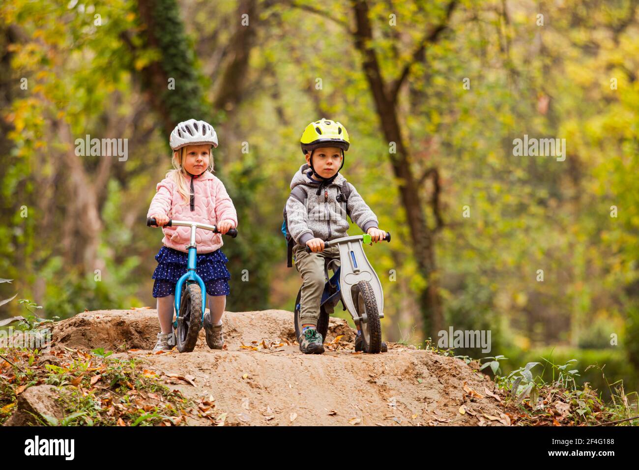 Two little friends sitting on balancing bikes Stock Photo - Alamy