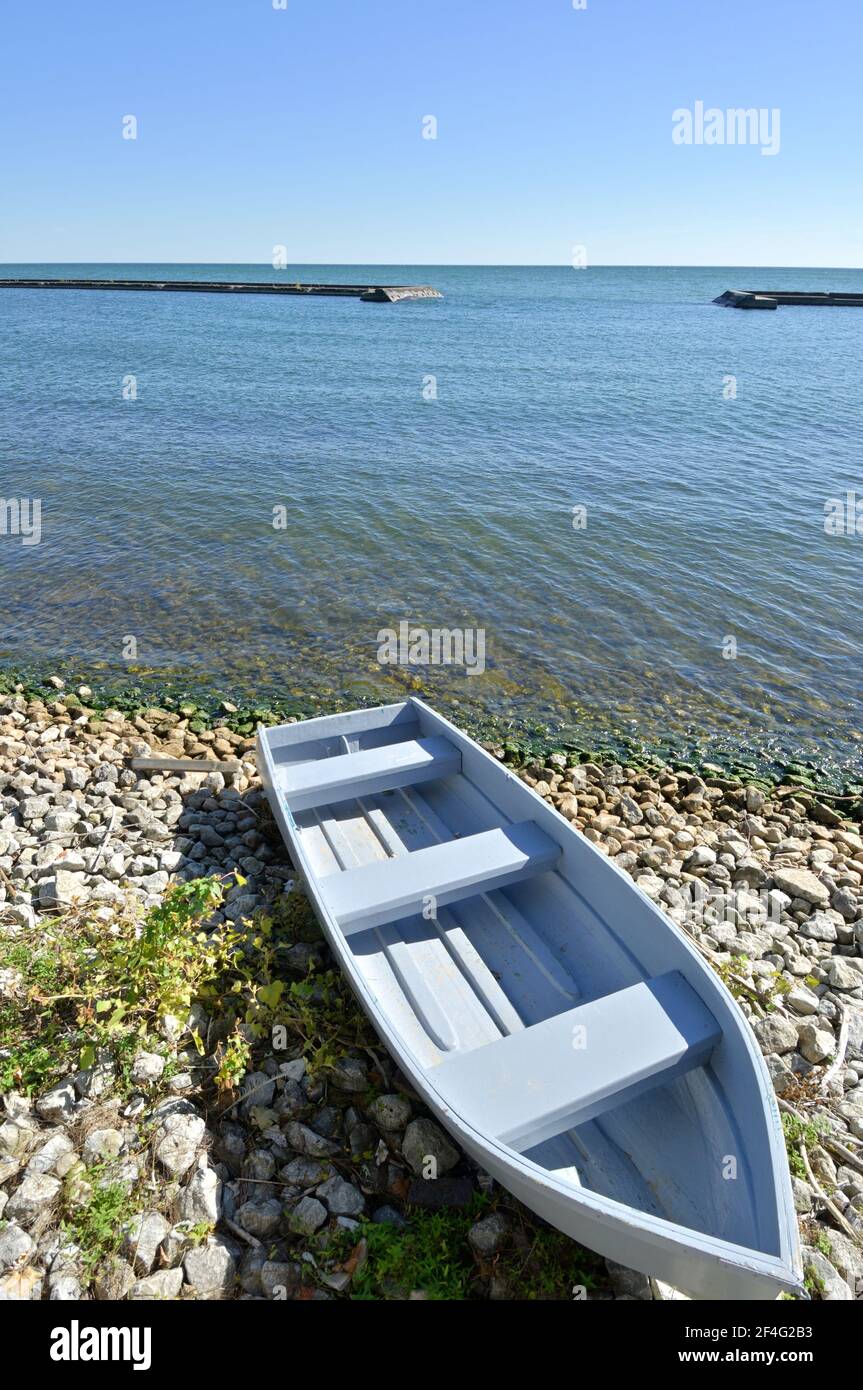 abandoned row boat at the edge of a large lake - day time Stock Photo ...