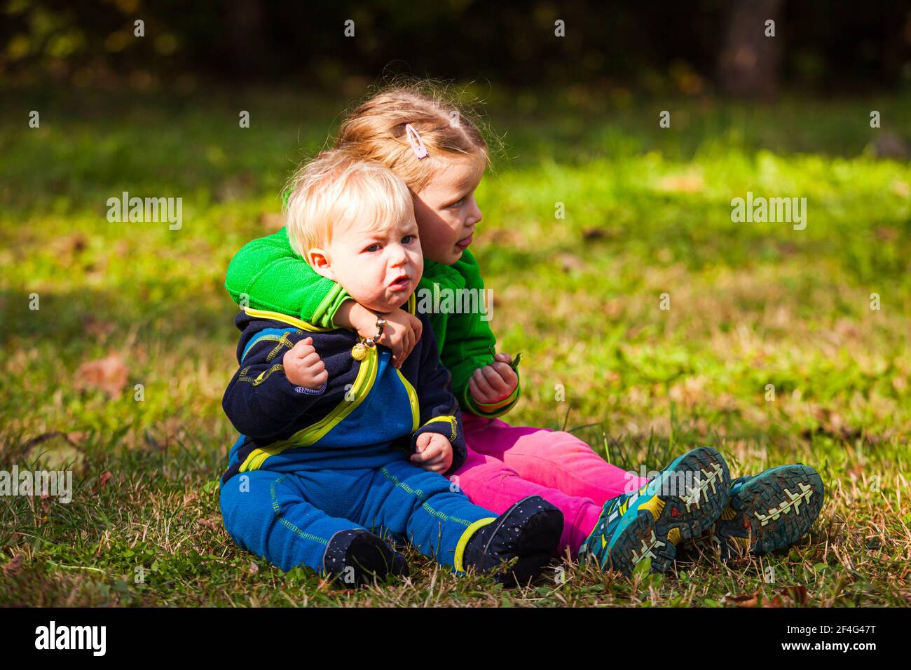 The cheerful girl is hugging her crying brother outdoor Stock Photo - Alamy
