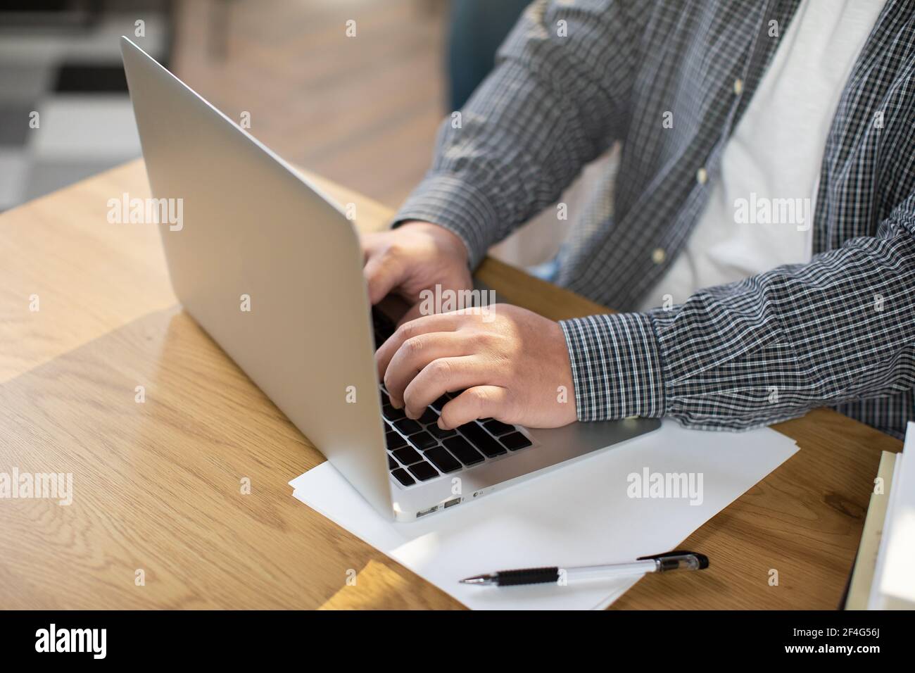Close up of male hands typing on keyboard of modern laptop. Young man ...