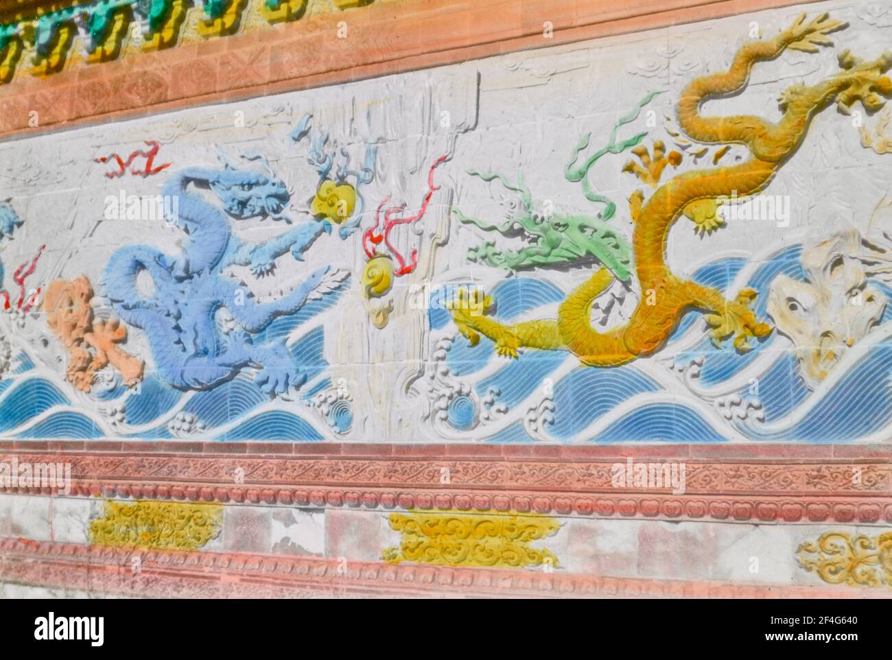 Angled close-up of two colorfully painted and carved dragons from the ...