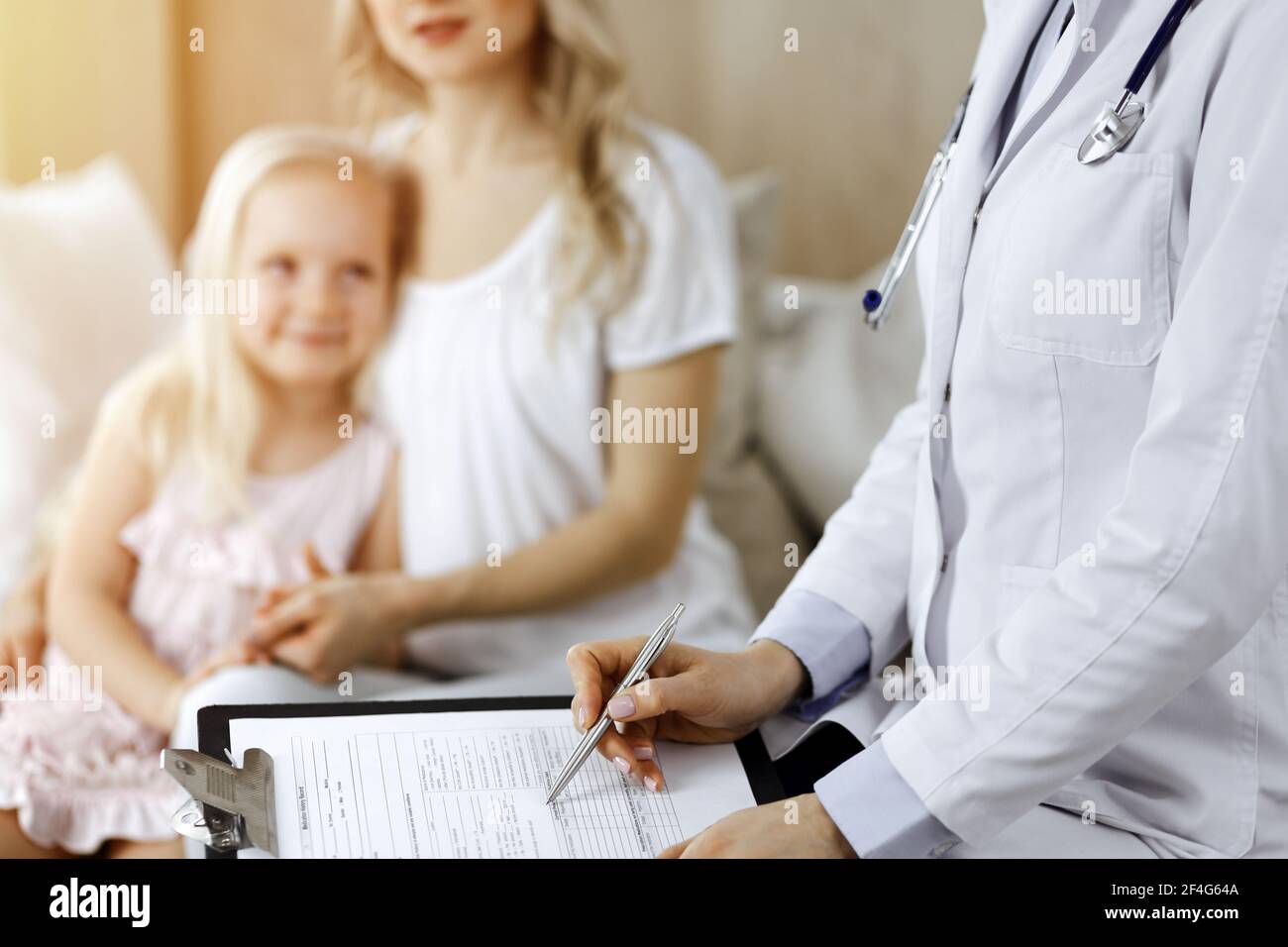 Doctor And Patient Pediatrician Using Clipboard While Examining Little doctor-and-patient-pediatrician-using-clipboard-while-examining-little