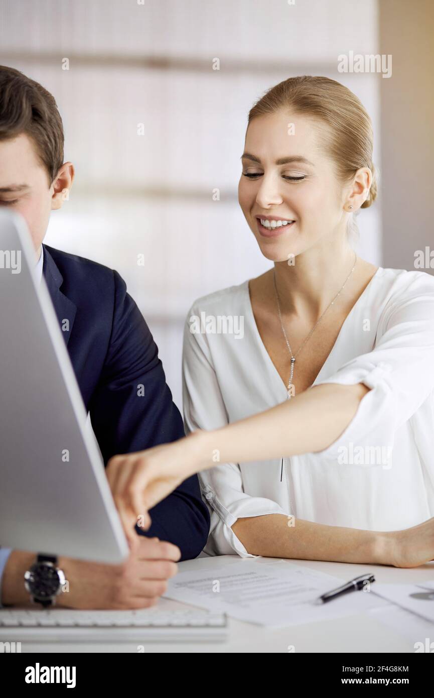 Business people discussing something while sitting in sunny office ...