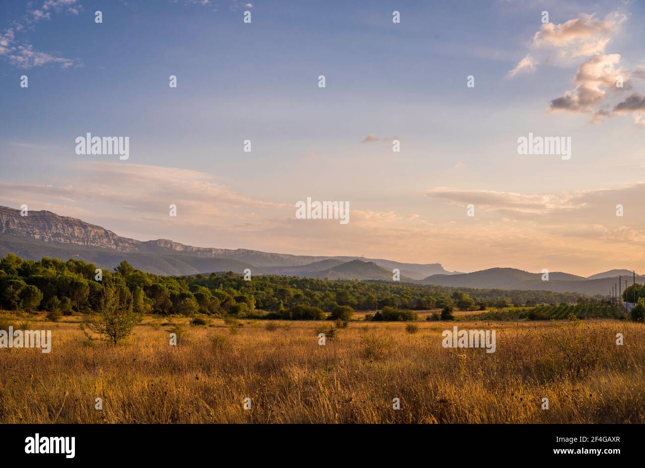 sunset in countryside with mountains in the back and fields in front ...