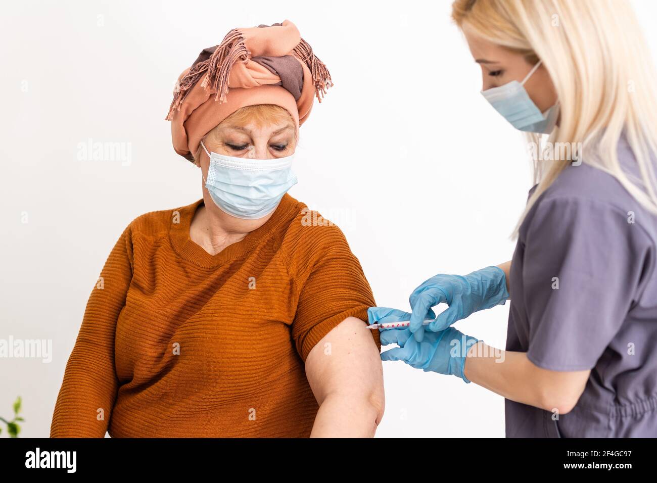 Nurse making vaccine injection to elderly patient Stock Photo - Alamy