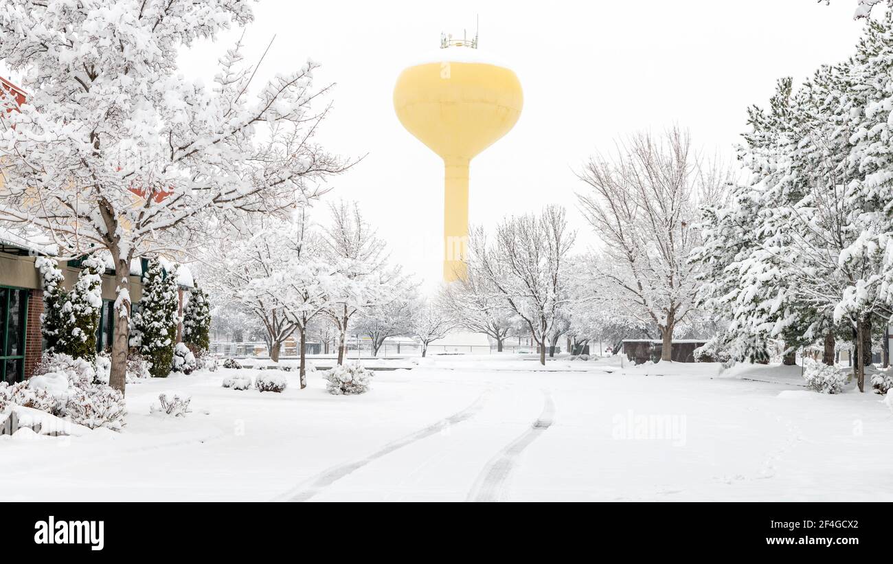 Yellow water tower above a winter snow parking lot Stock Photo - Alamy