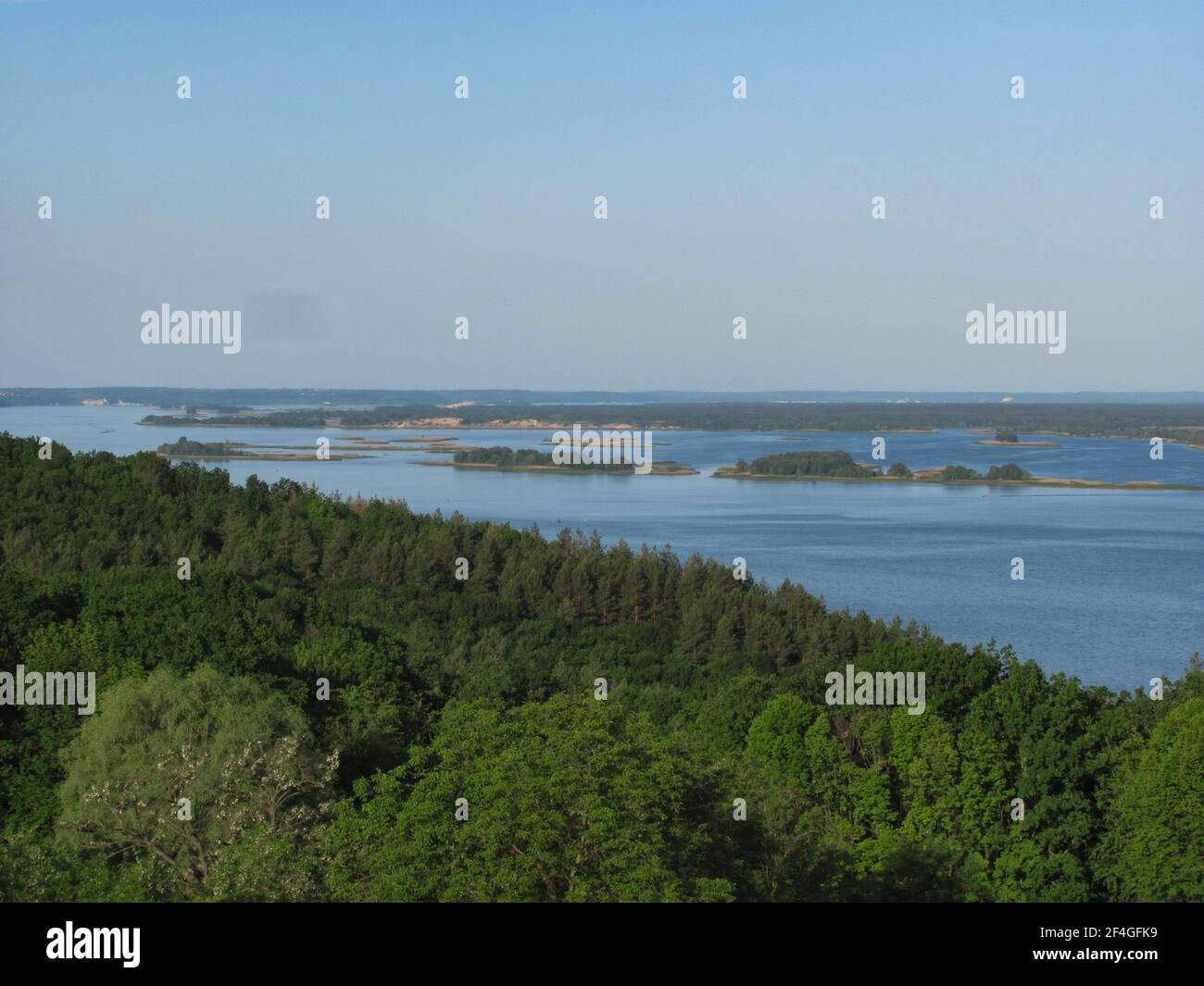 landscape background: green forest, river with islands and blue sky ...