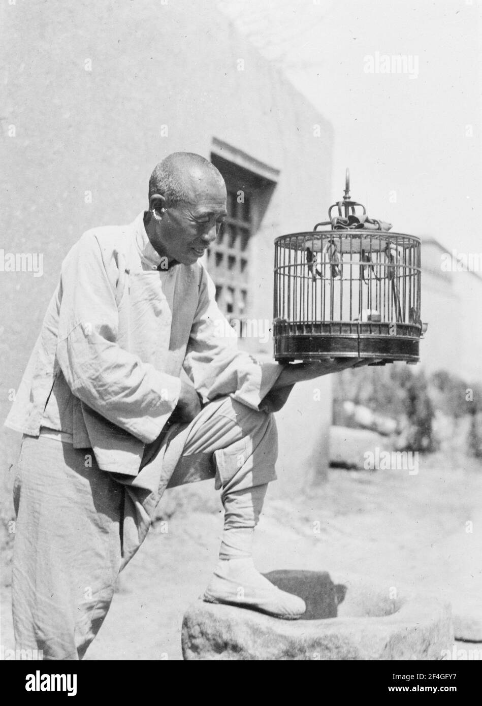 Man airing bird, China, Beijing (China), 1919. From the Sidney D ...