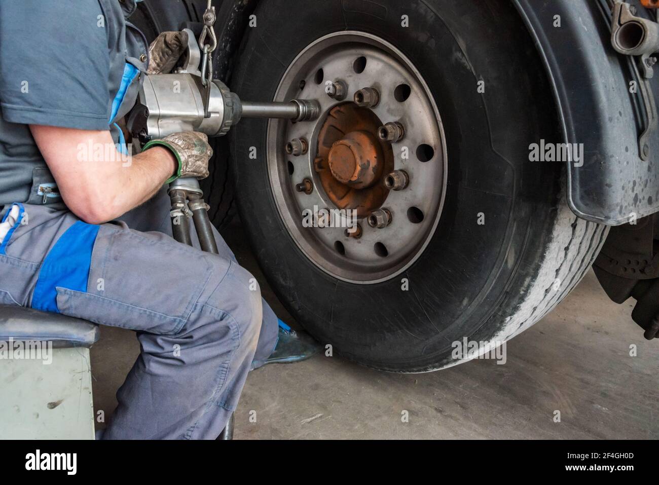 Tire workshop operator who uses a machine to mount or remove a truck ...