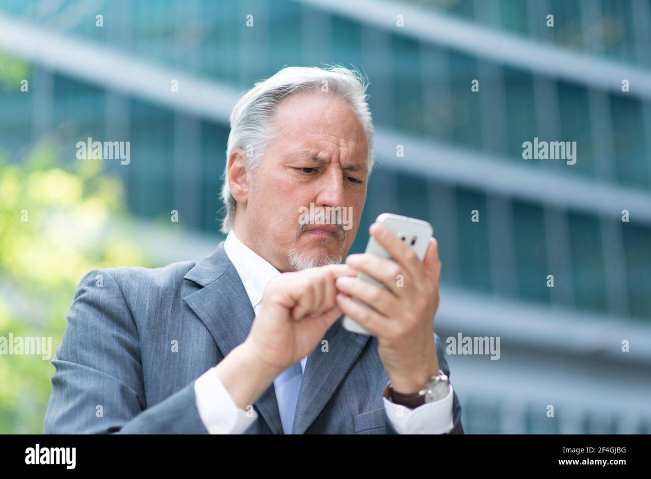 Portrait of a senior businessman having a difficult time while using ...