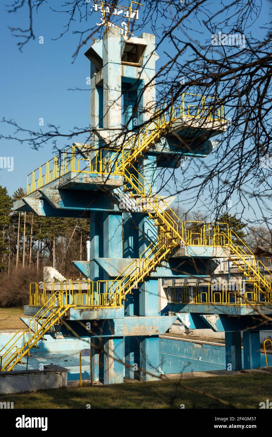 Concrete diving tower and disused blue swimming pool at abandoned ...