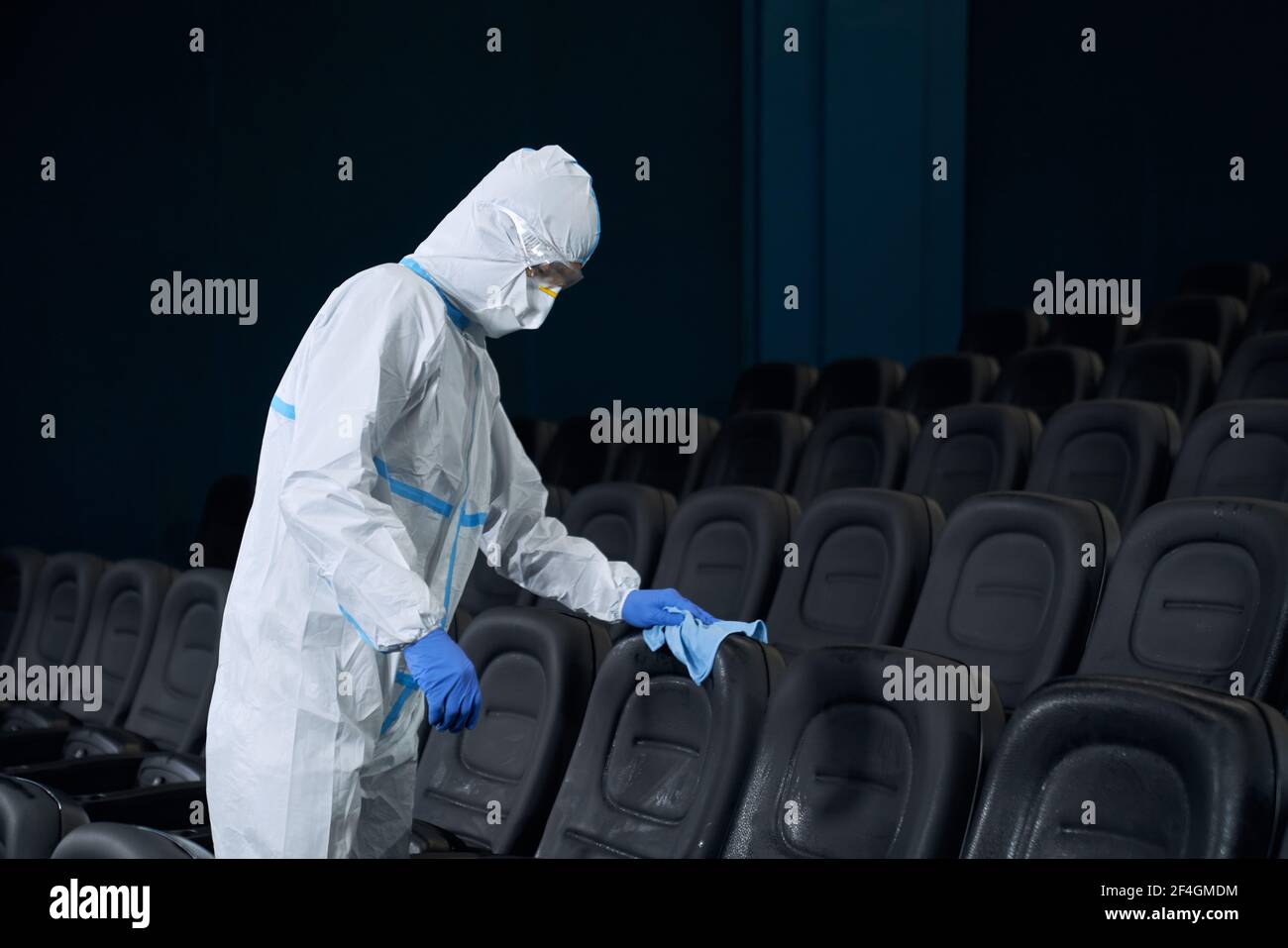 Special worker in protective suit making disinfection chairs against ...