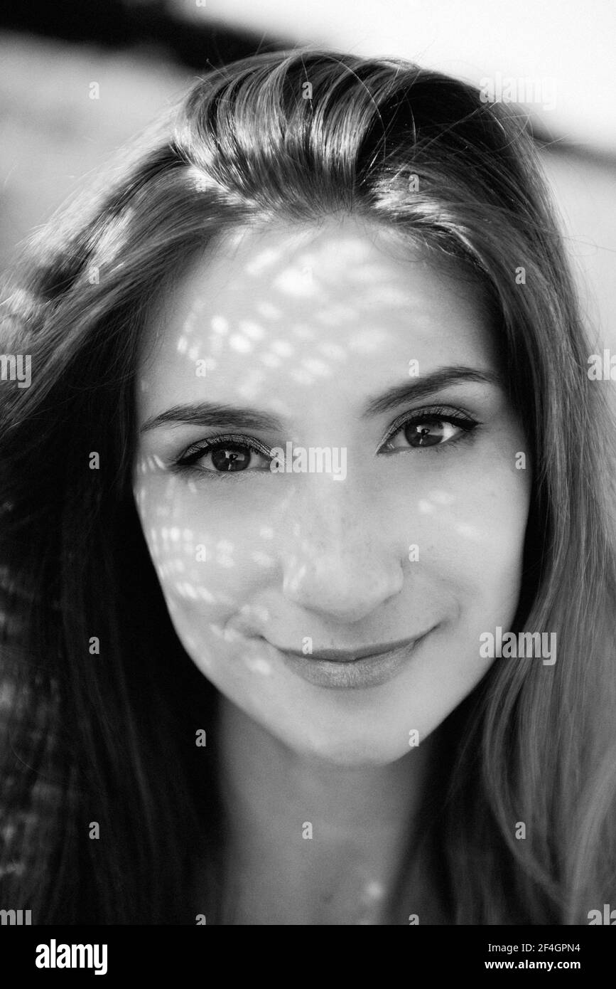A very close-up black and white portrait of a young woman with sunny ...