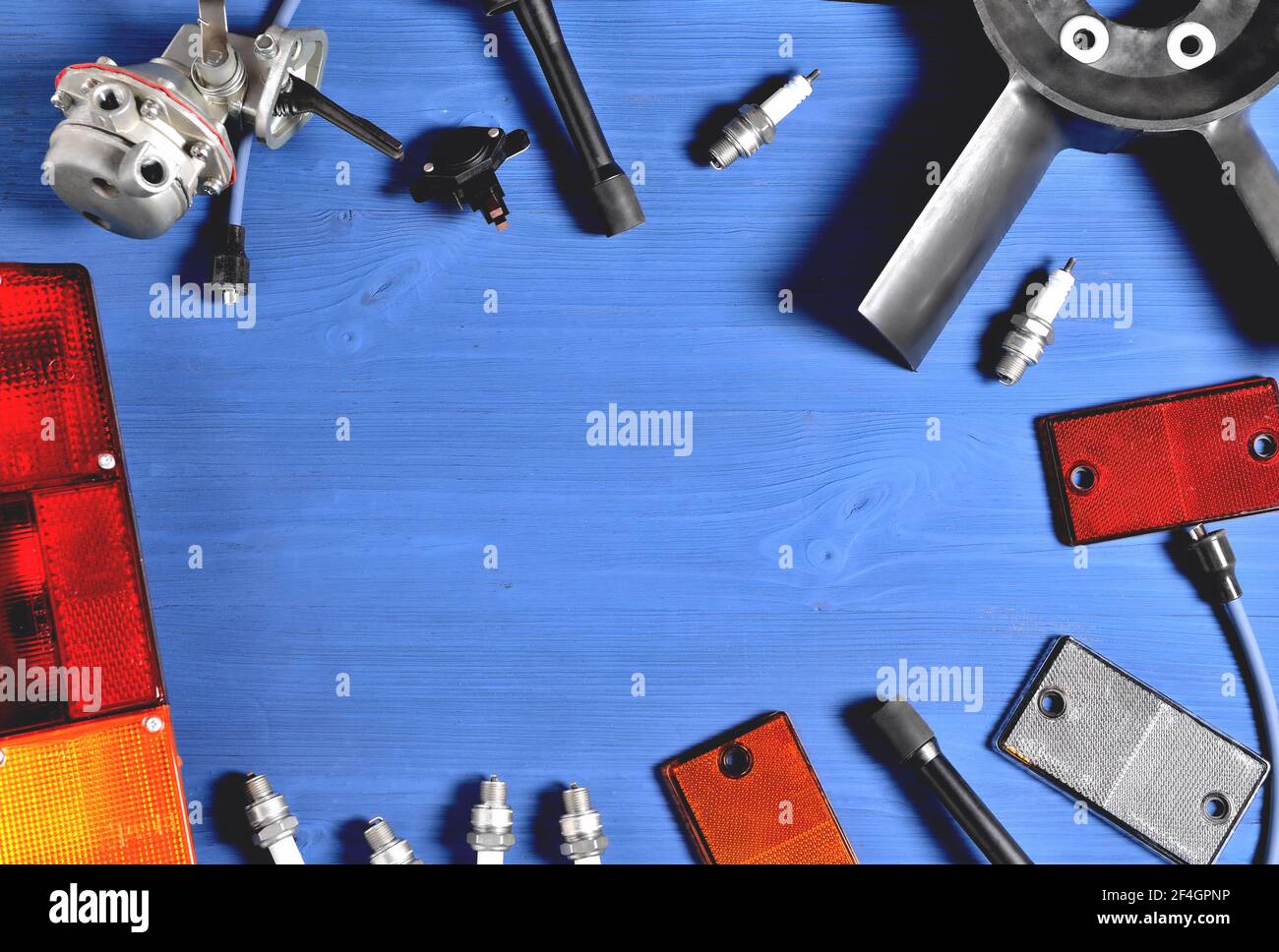 auto parts on a wooden blue background lights, reflectors, spark plugs ...