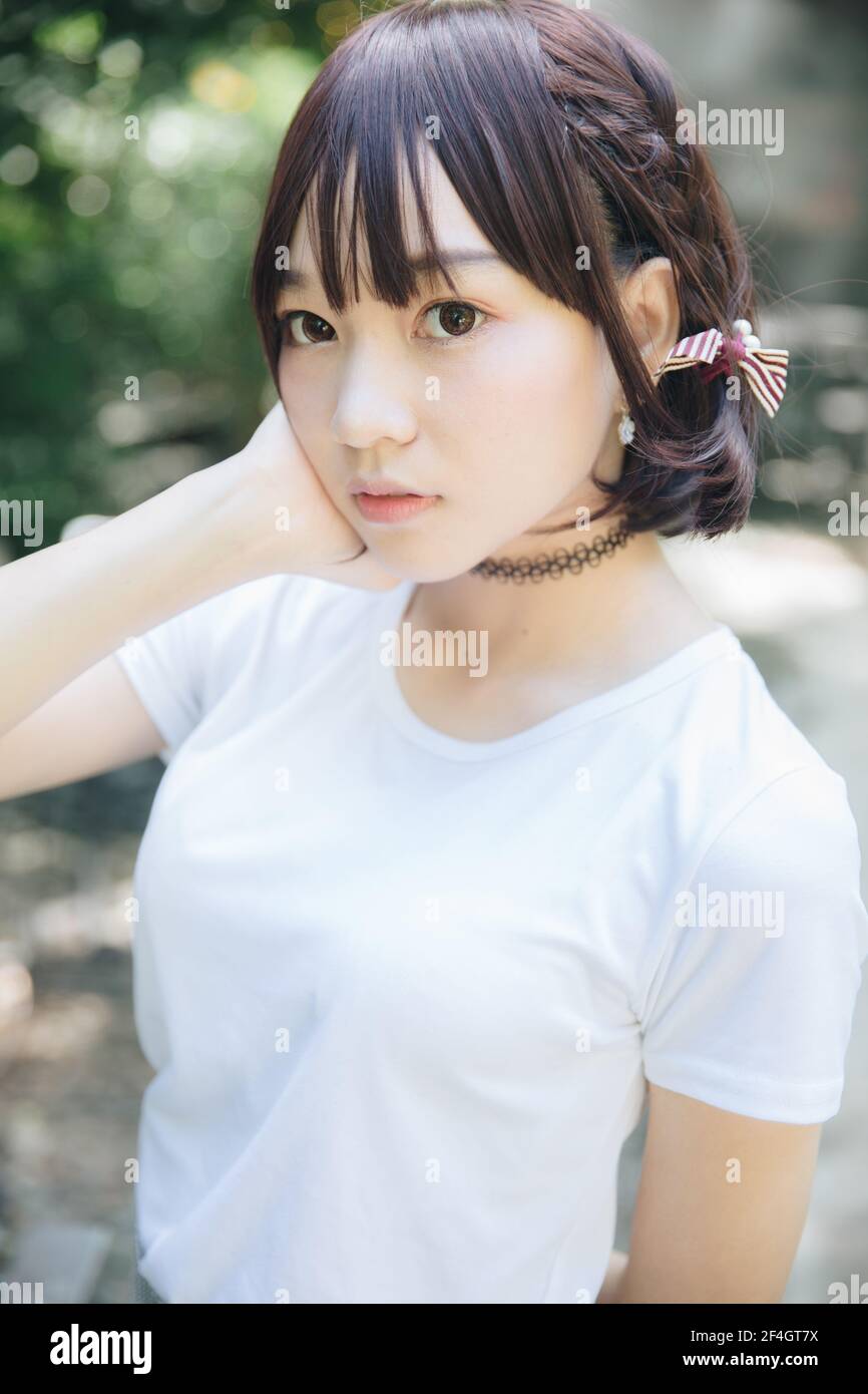 portrait of asian girl with white shirt and skirt looking in outdoor ...
