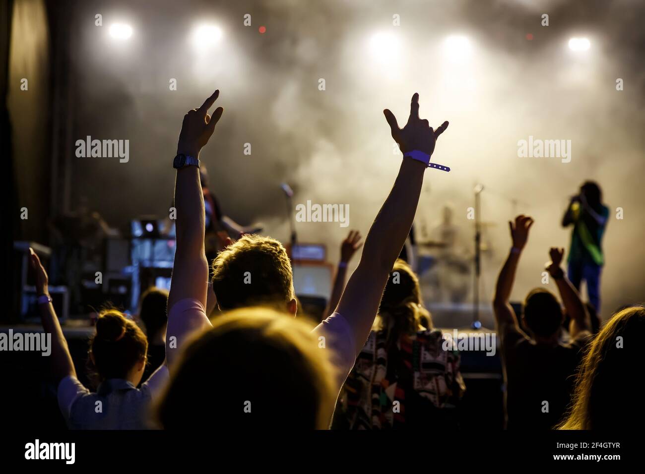 Rock concert, cheering crowd in front of bright colorful stage lights ...
