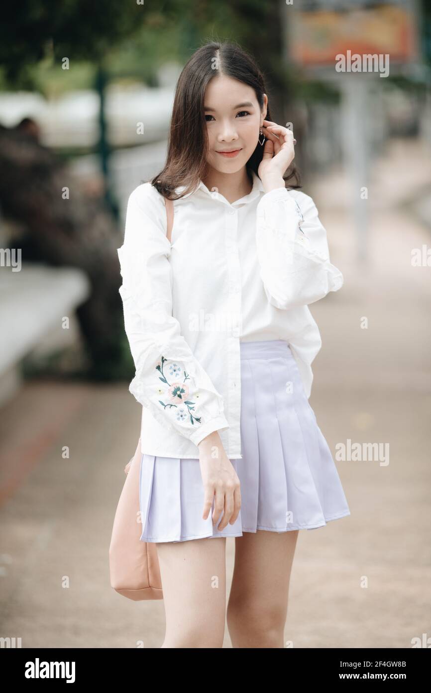 portrait of asian girl with white shirt and skirt looking in outdoor ...