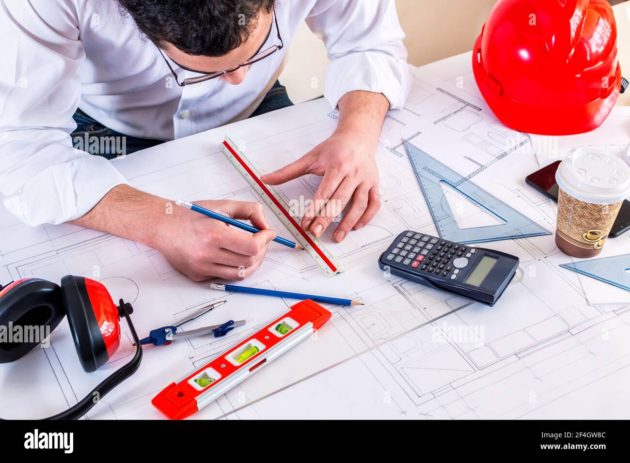 A Caucasian civil engineer correcting a blueprint, sketching a ...