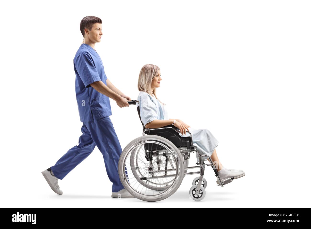 Full length profile shot of a male healthcare worker pushing a female ...