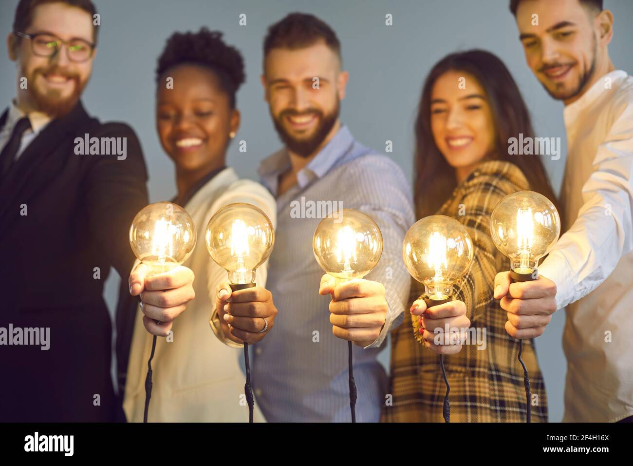Group of happy creative young diverse business people holding shining ...