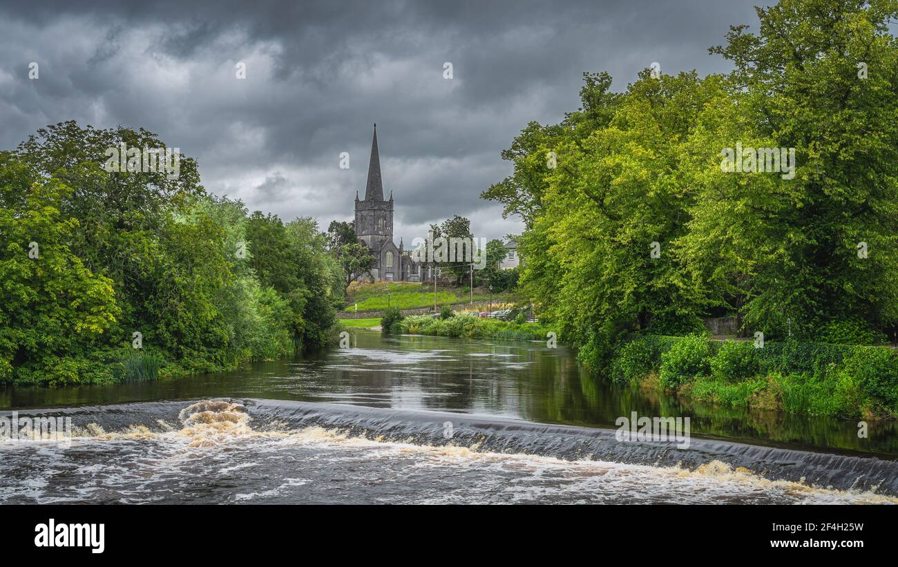 Cascades of water and small waterfall on Suir River surrounded by lush ...