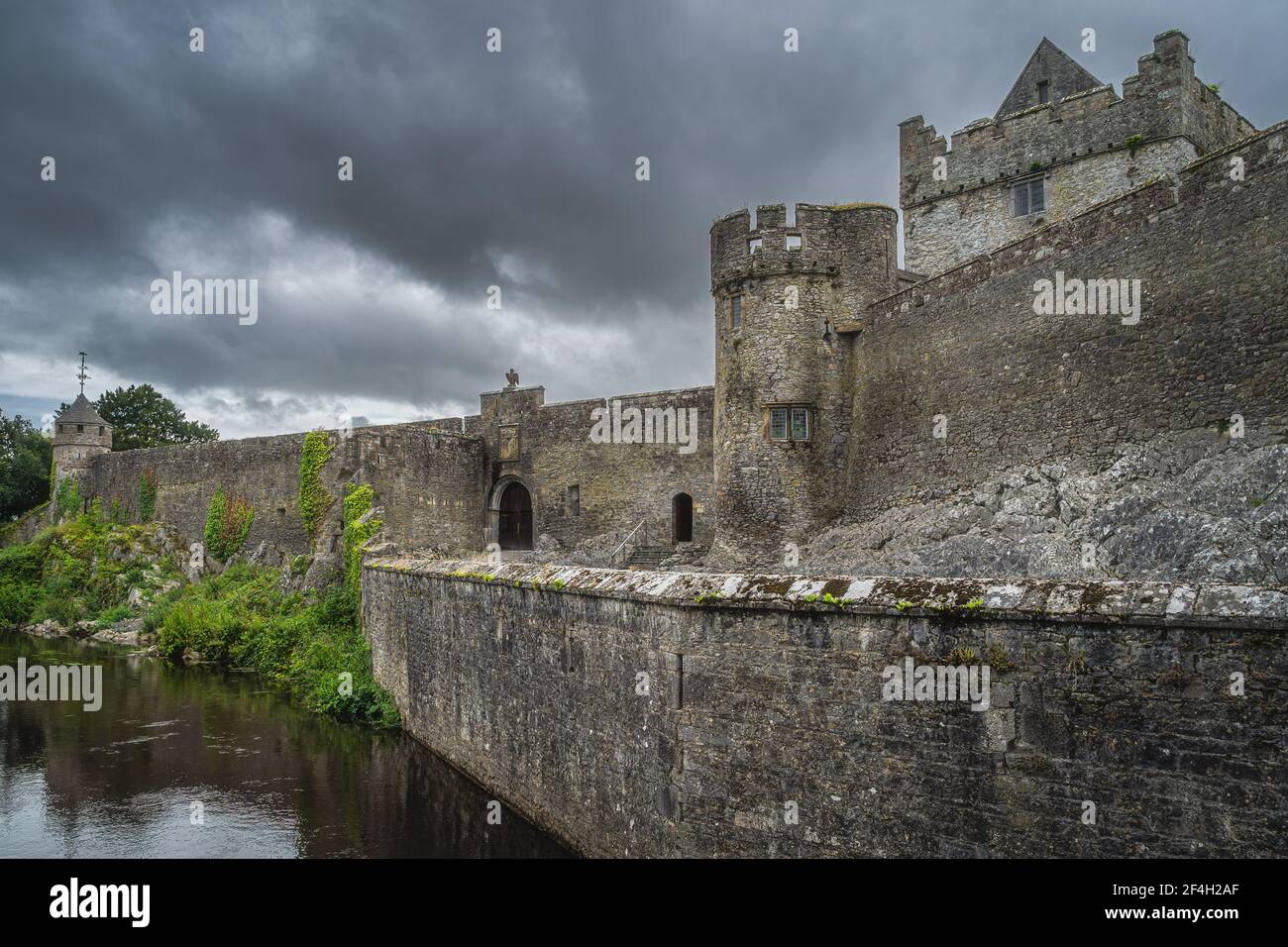 Tall stone walls and moat of 11th century Cahir castle in Cahir town ...