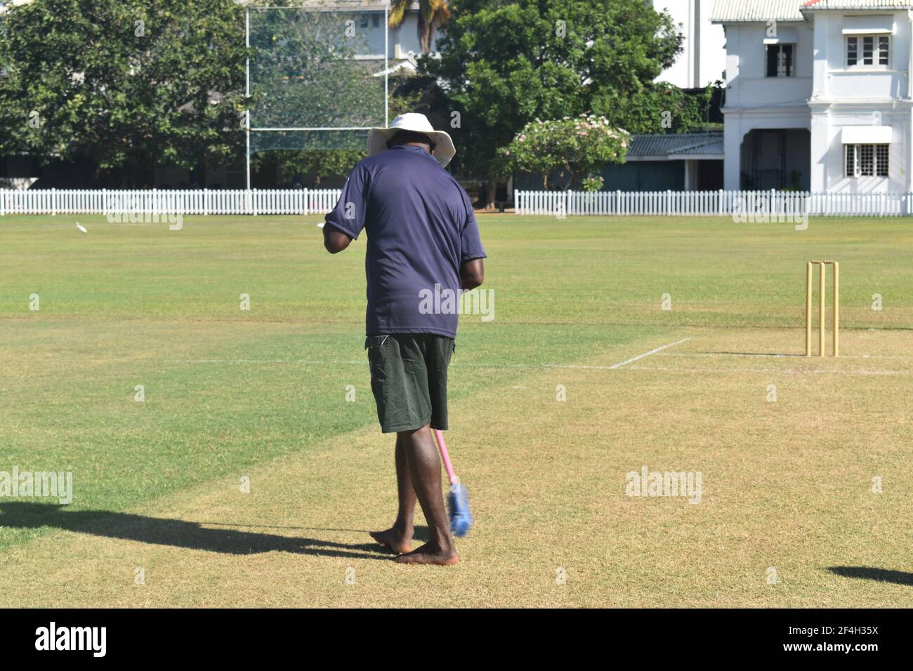 Ground staff preparing the turf wicket and ground for a cricket match ...