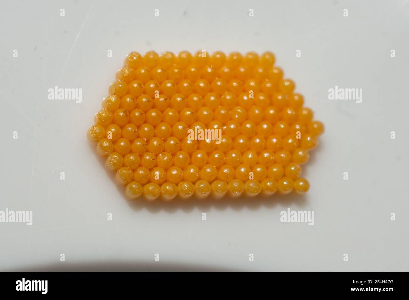 Yellow color insect eggs forming an almost perfect hexagon on a white ...