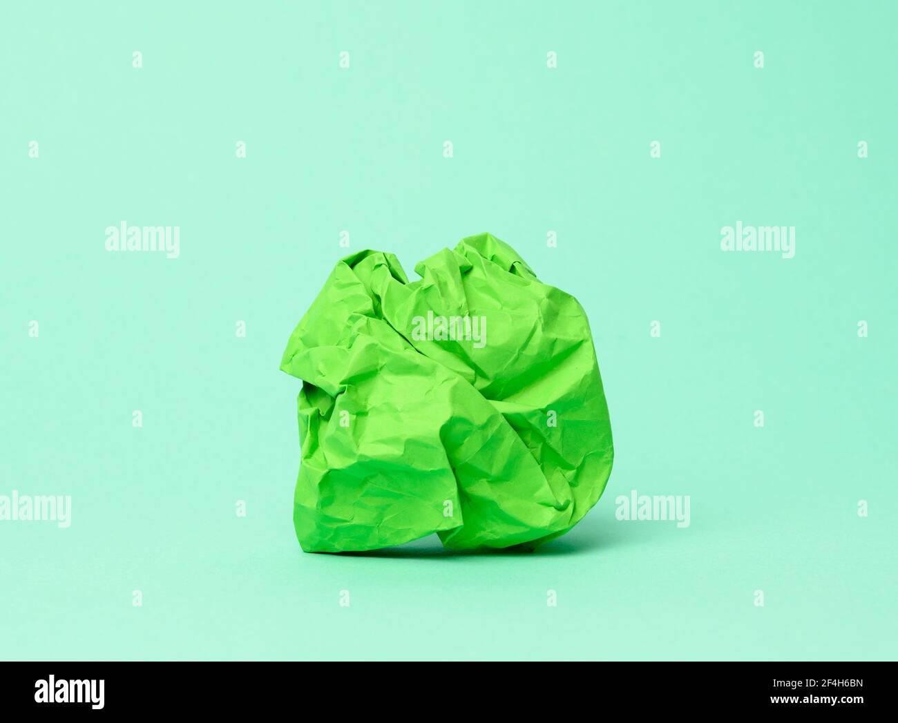 crumpled ball of green paper on a green background, close up Stock ...