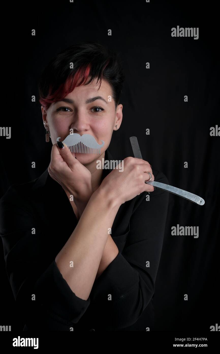 Half length portrait of young adult barber woman on black background ...