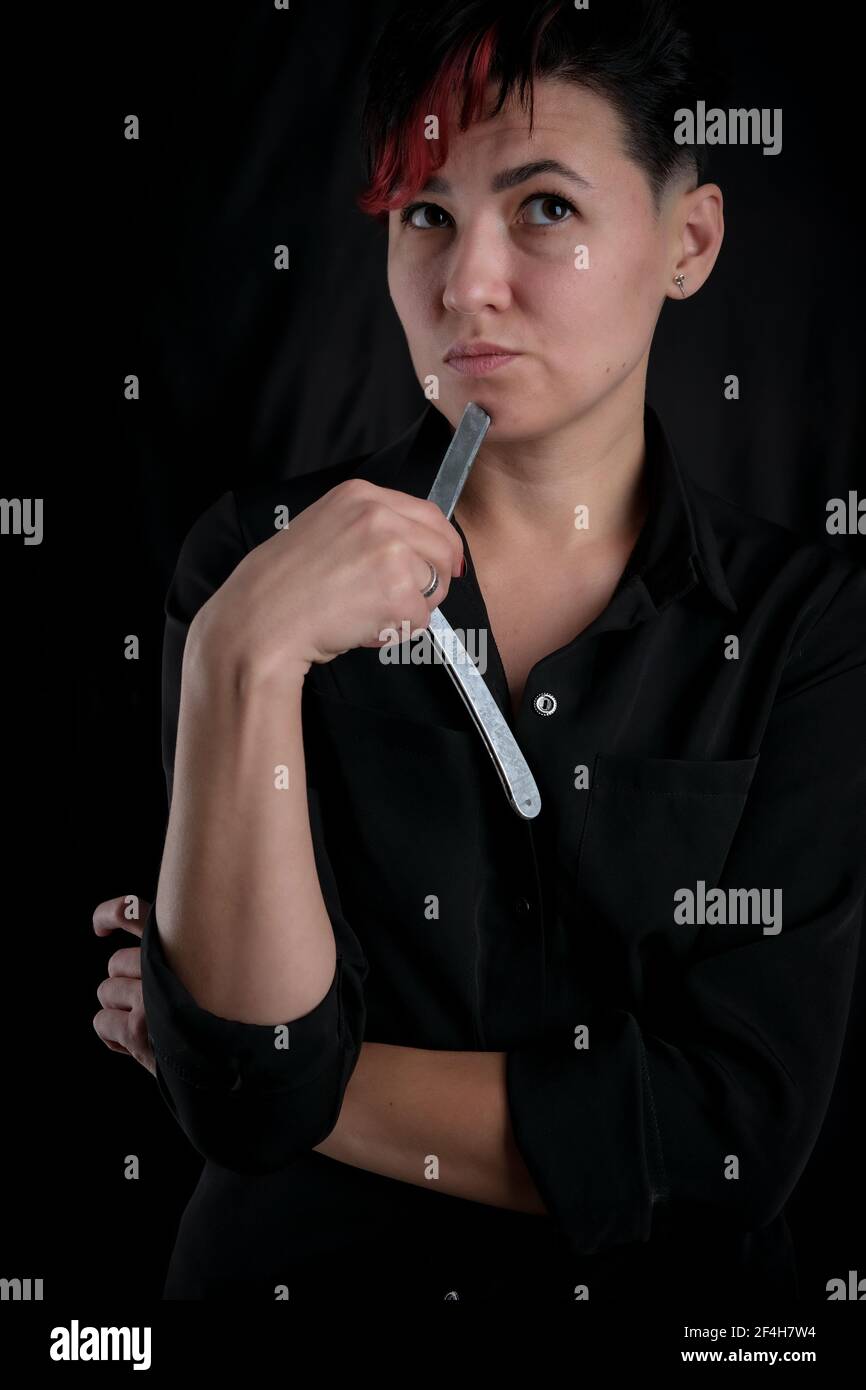 Half length portrait of young adult barber woman on black background ...