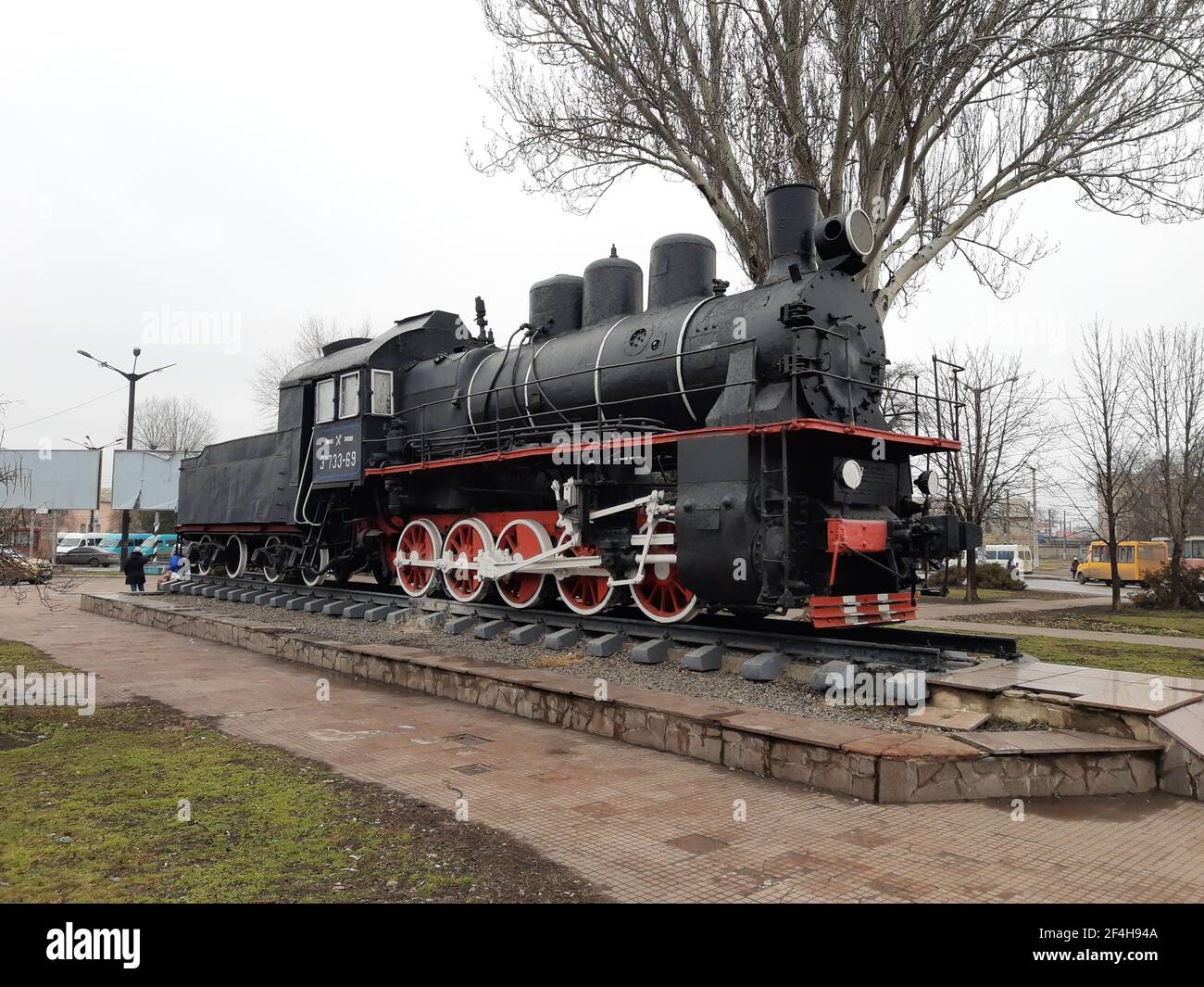 An old black steam locomotive on rails and a concrete platform in the ...