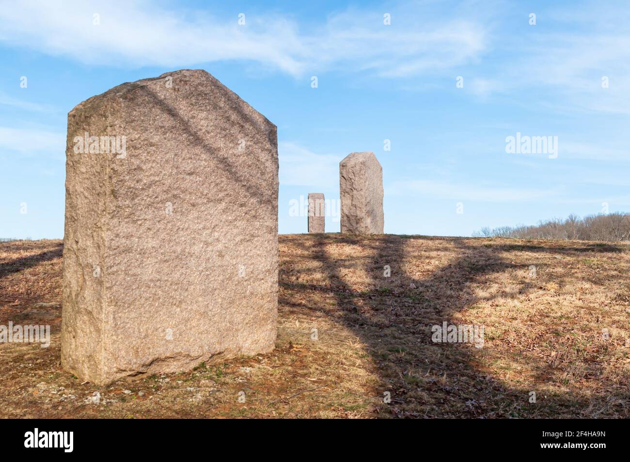 A shadow from a tree cast near three stone monuments at Gettysburg ...