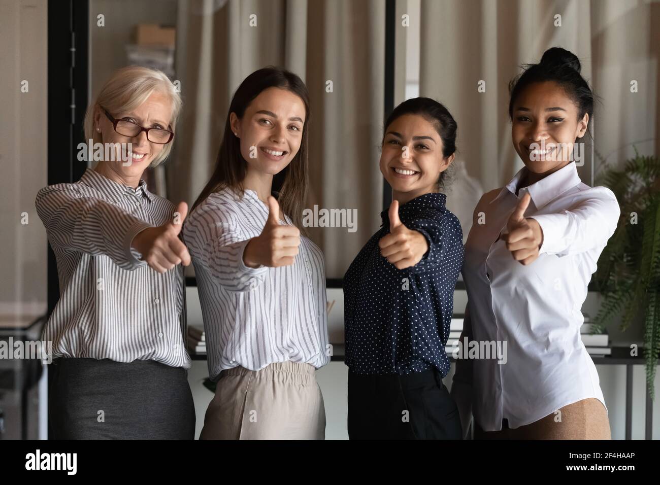 Portrait of smiling female employee show thumbs up Stock Photo - Alamy