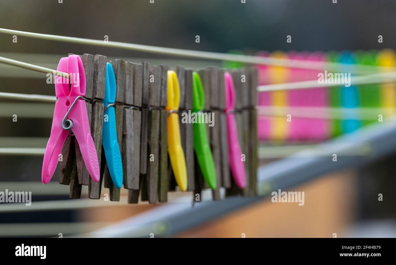 Plastic and wooden clothes pegs hanging from a clothes line. Air drying ...