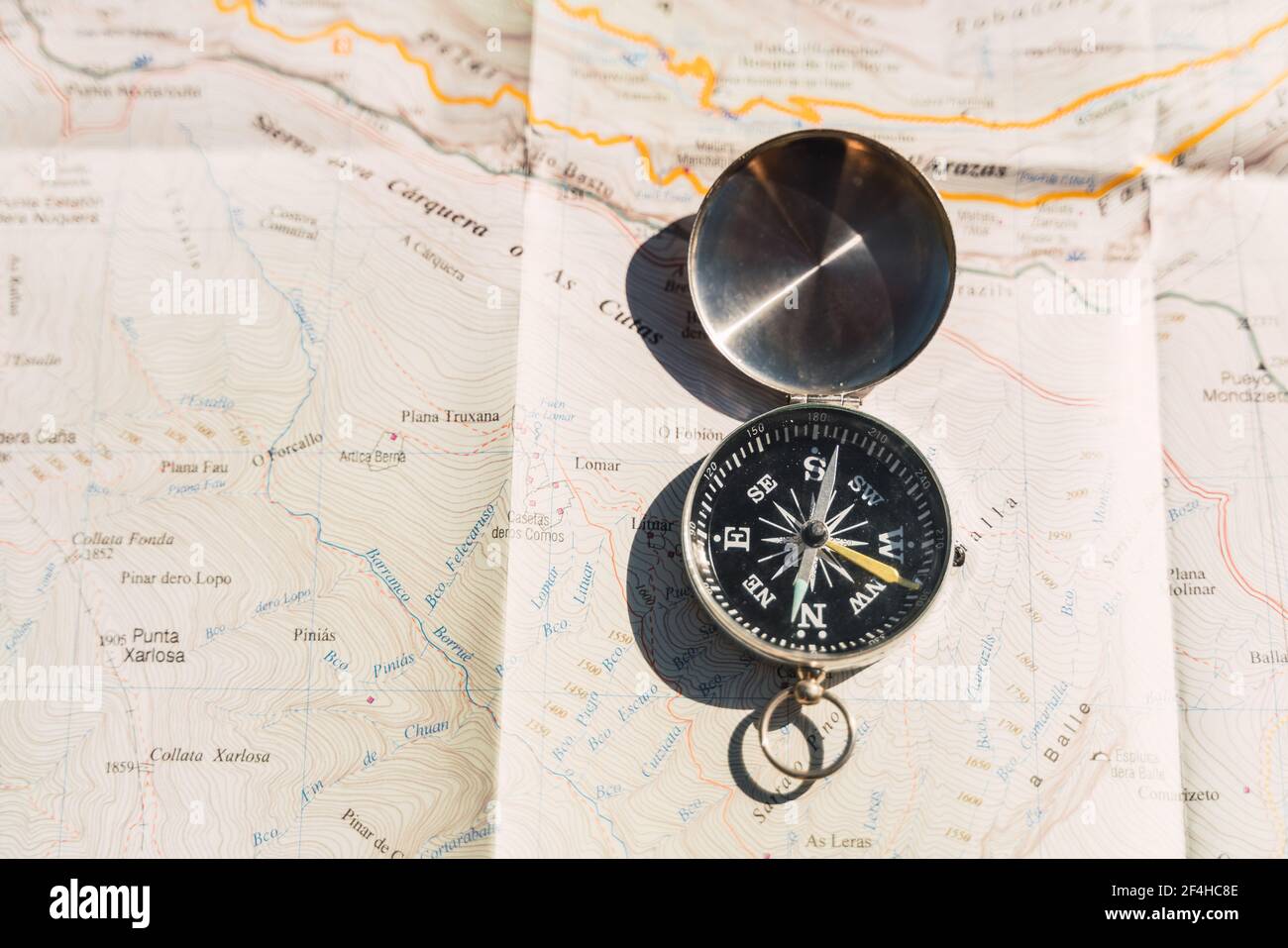 From above of retro compass placed on paper map showing concept of ...