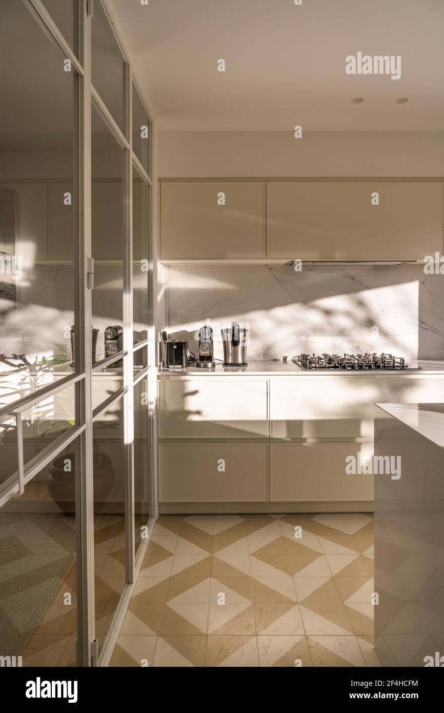 Interior of contemporary home kitchen with light furniture and mirrored ...