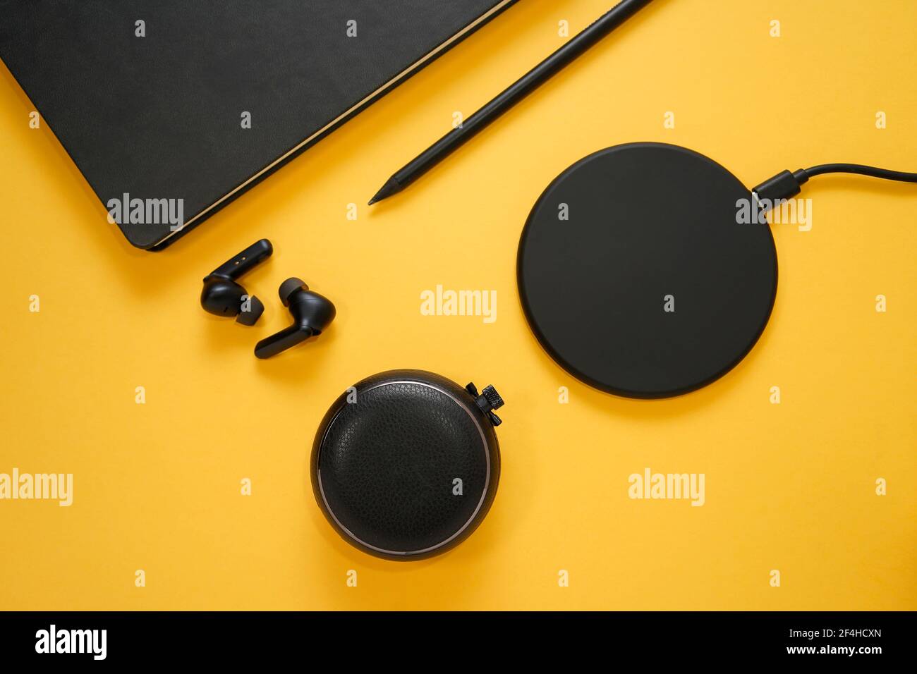 Top view composition with black true wireless earbuds near case placed ...