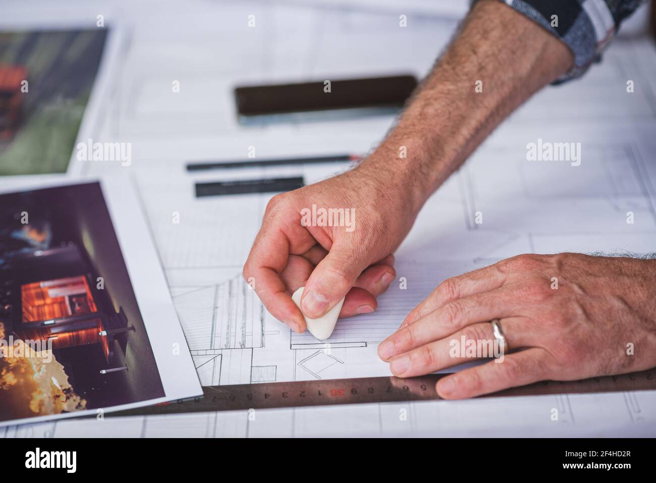 Crop unrecognizable male architect creating draft of building and ...