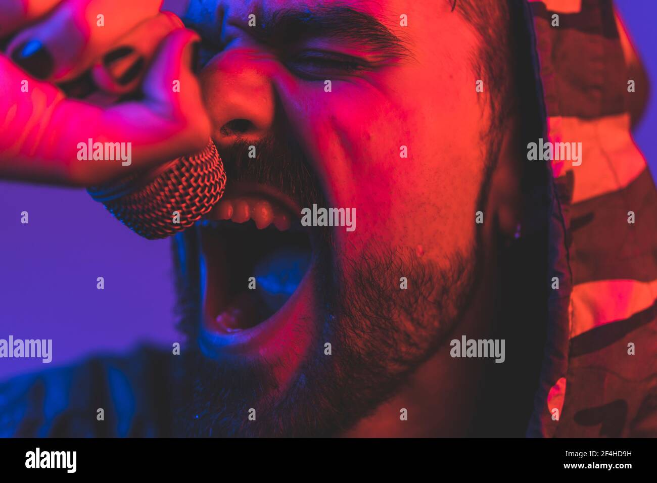 Adult bearded male singer in hooded jacket performing expressive song ...