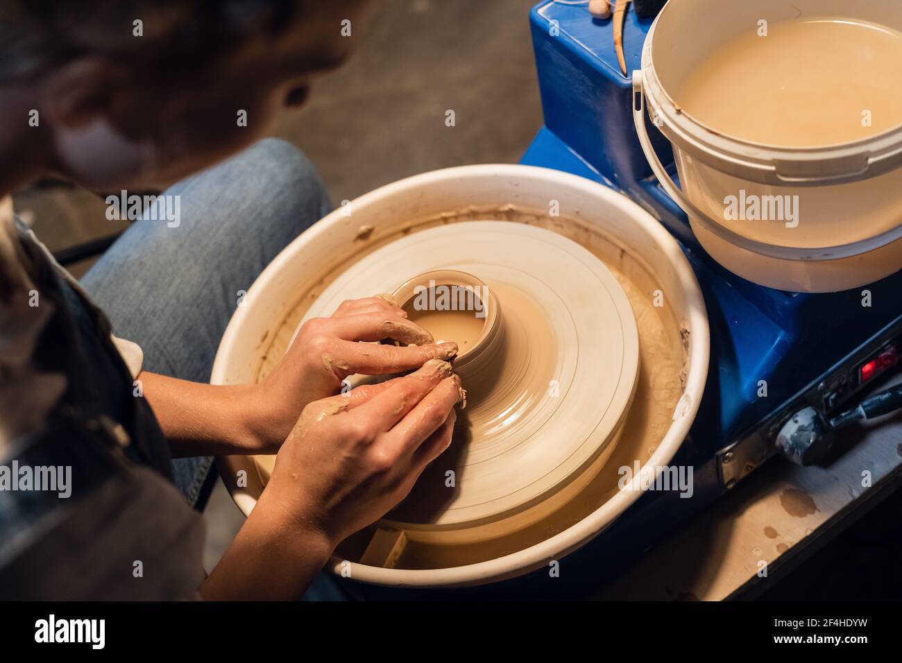 beautiful hands of a young girl, stained with clay when modeling a pot ...