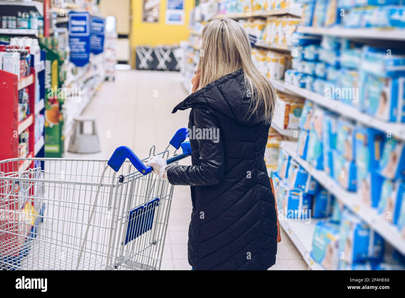 Rear view of blonde woman shopping in supermarket Stock Photo - Alamy