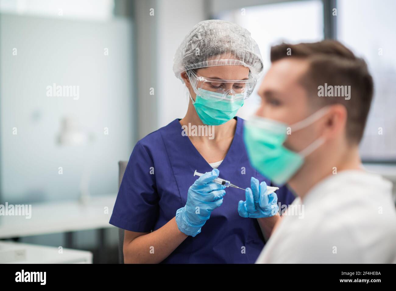 In the laboratory at the hospital, a nurse gives an injection into the ...