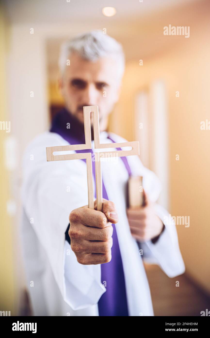 Catholic priest's hand with a wooden cross symbol Stock Photo - Alamy