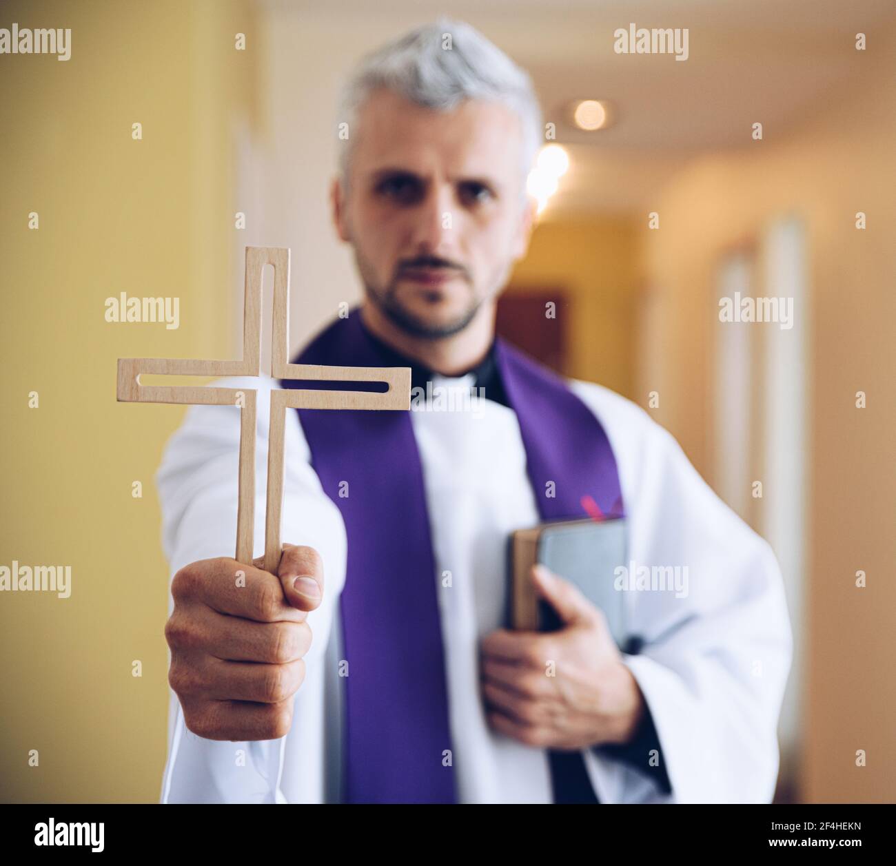 Handsome priest holding wooden cross in hand Stock Photo - Alamy