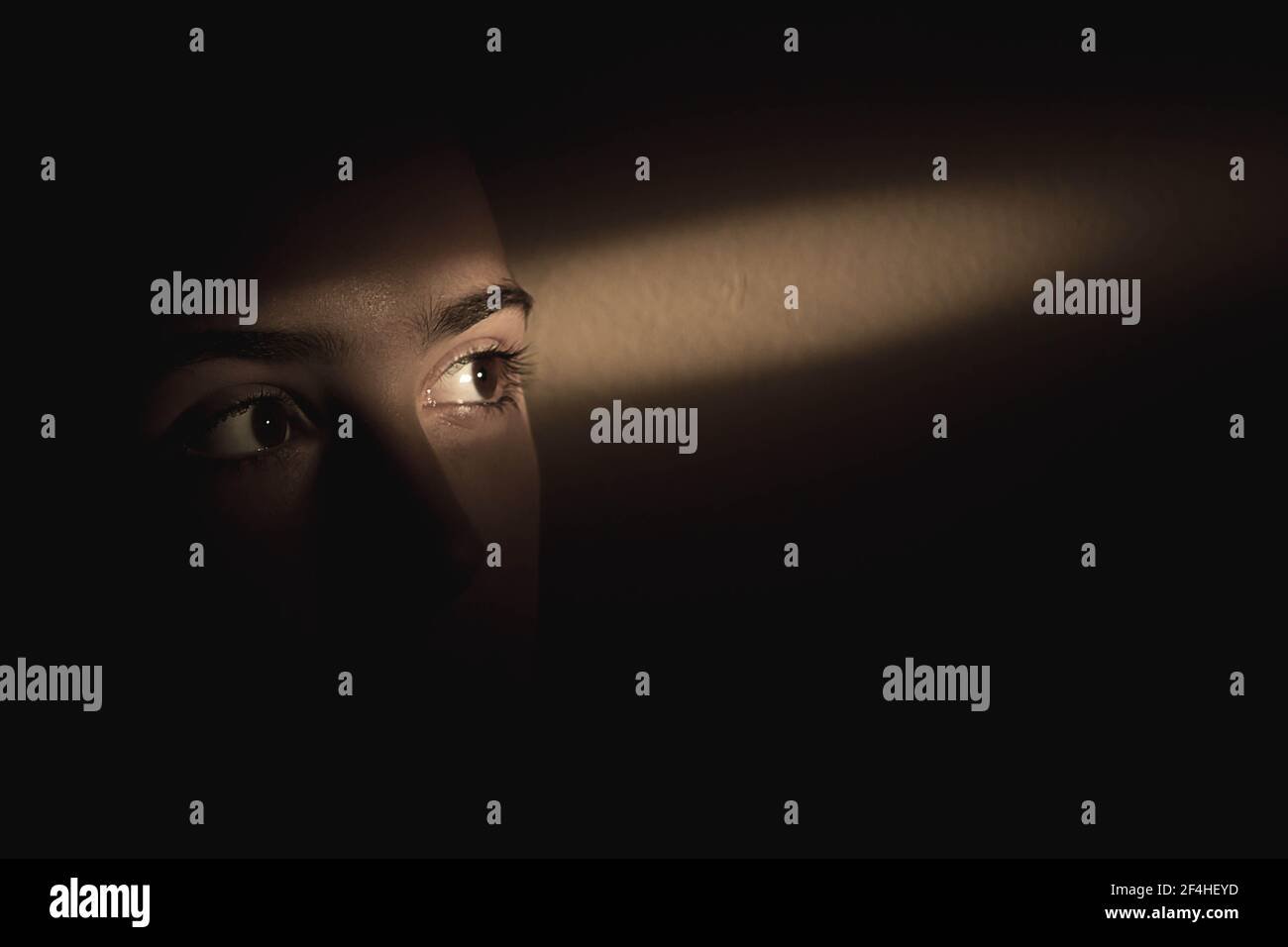 Single ray of light falling over girls eyes Stock Photo - Alamy