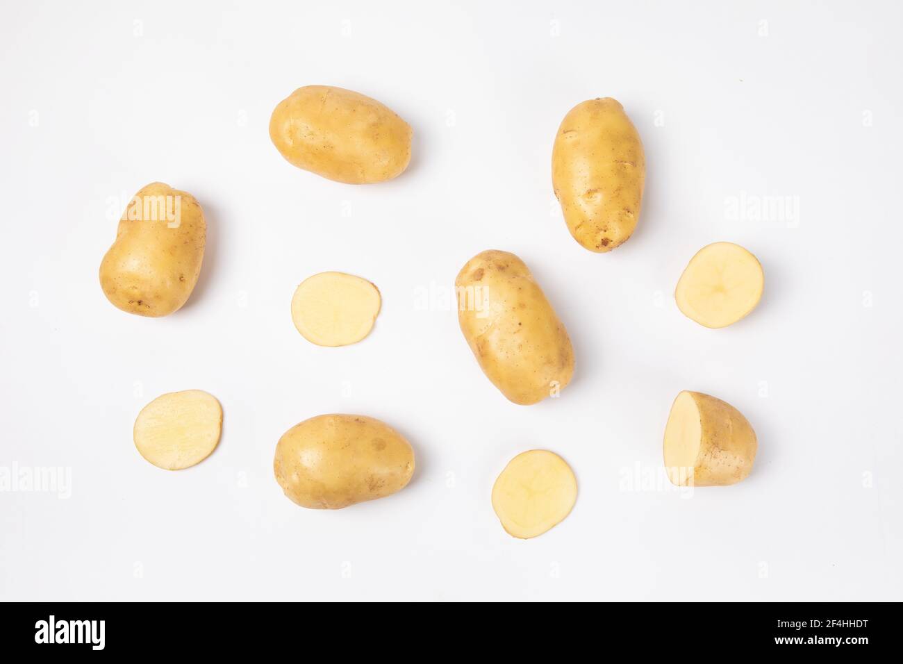 A top view of raw potatoes and cut pieces isolated on white background ...