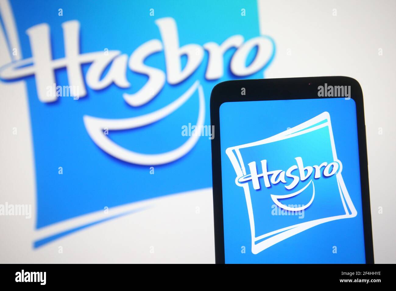 In this photo illustration a Hasbro logo is seen on a smartphone and a ...