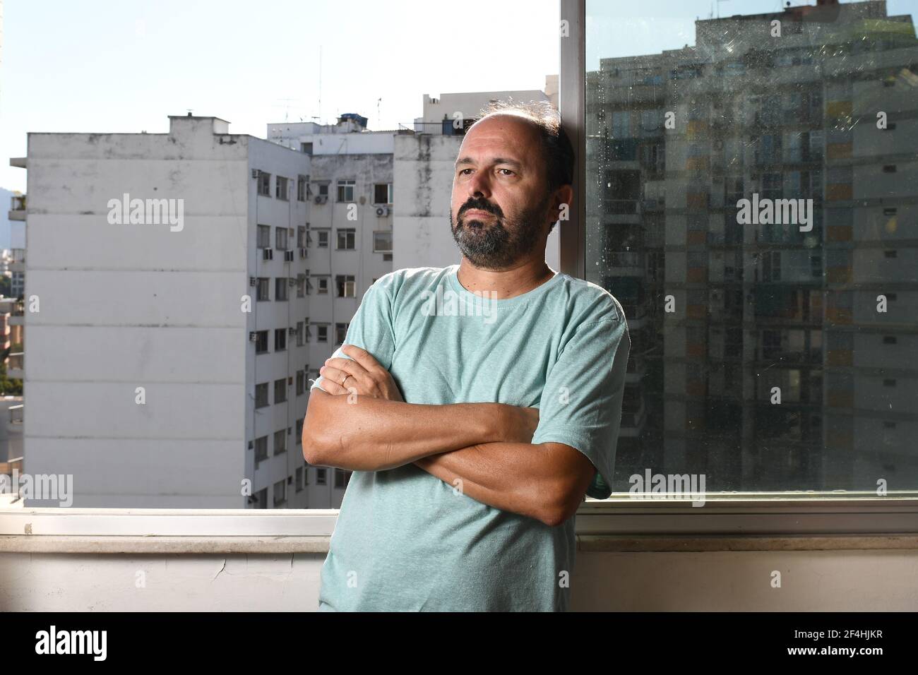 man leaning by the window with thoughtful expression Stock Photo - Alamy