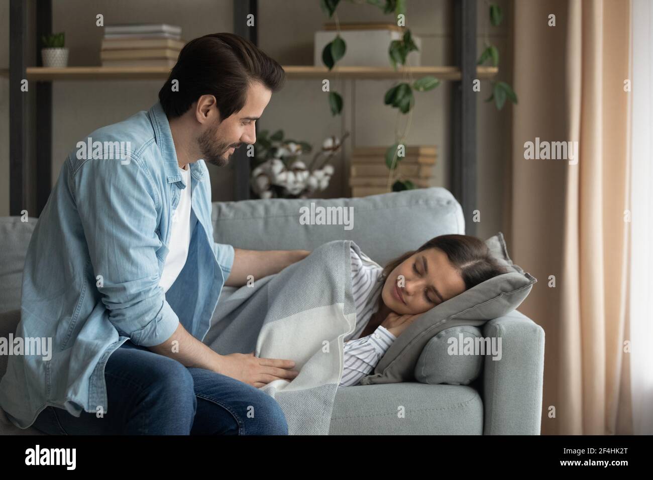Caring loving man covering sleeping woman with warm blanket Stock Photo ...